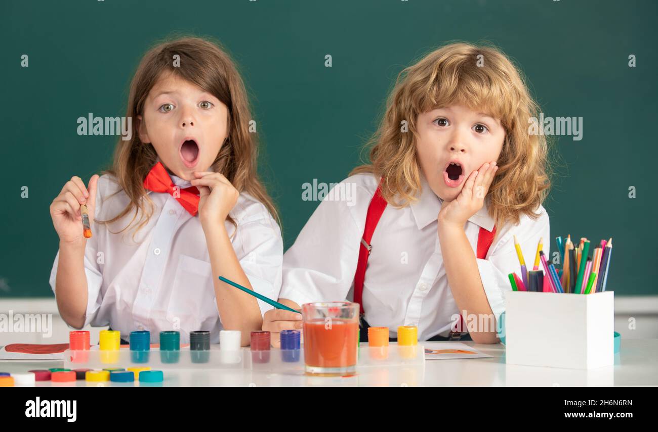 Excited school surprised children drawing a colorful pictures with ...