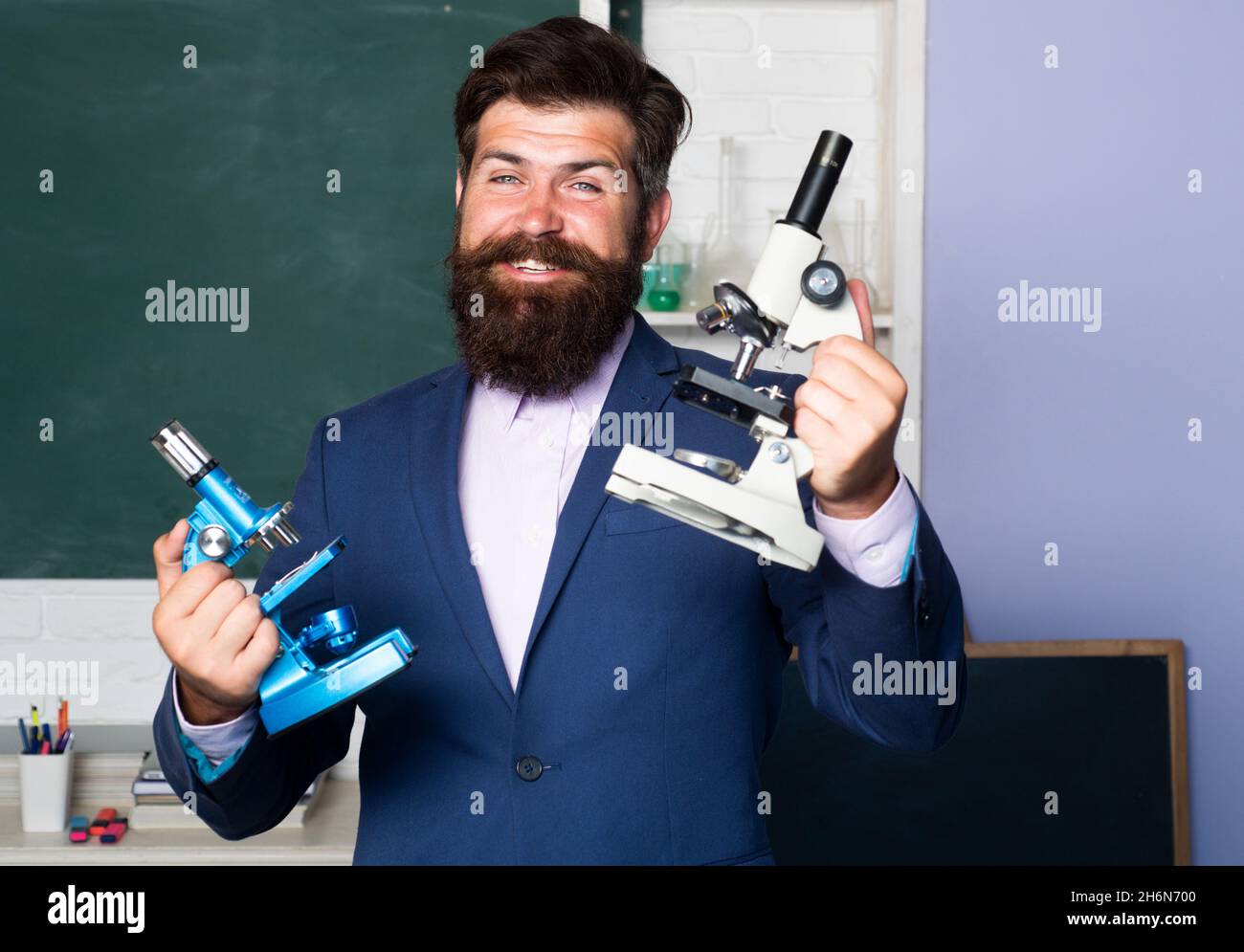 Portrait of a happy smiling teacher, tutor, professor in a classroom ...