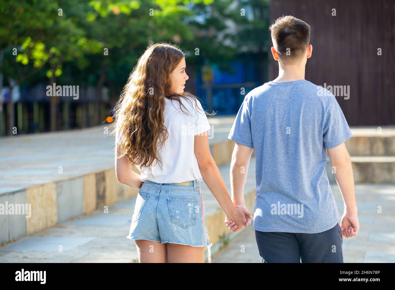 A couple of teenagers is staying and holding hands Stock Photo - Alamy