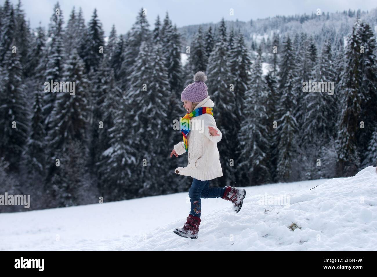 Funny child, cute girl running in winter snowy park. Christmas holiday ...