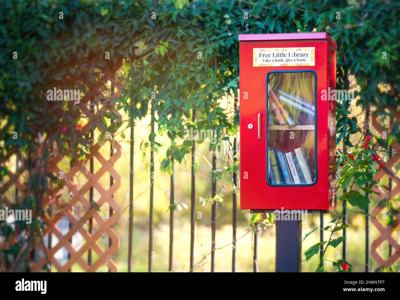 Red Little Free Library box in a quiet neighborhood park surrounded by ...