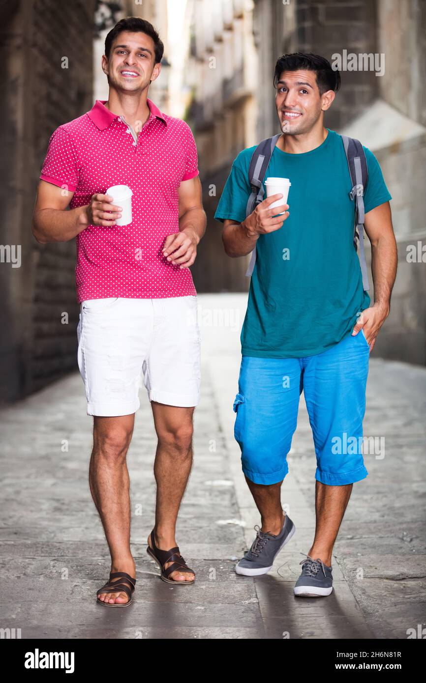 Male tourists walking with coffee Stock Photo - Alamy