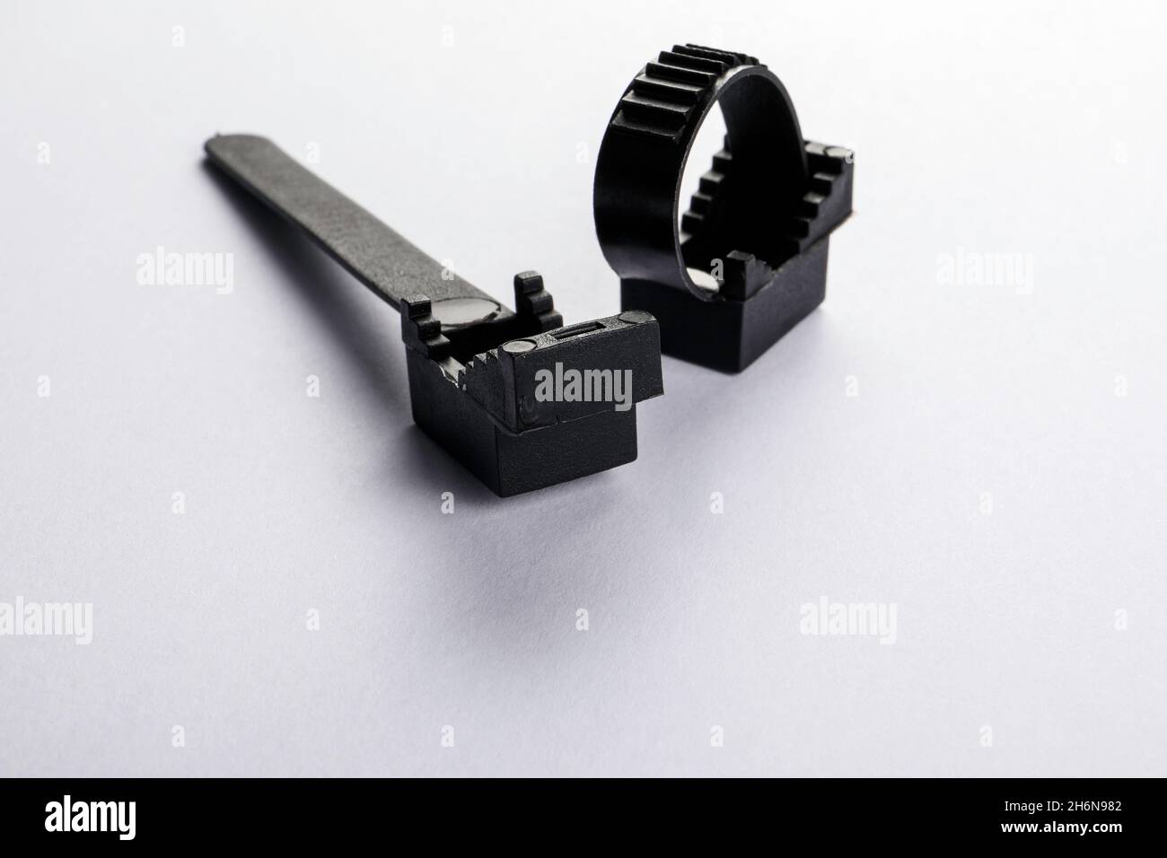Two black wire clamps on a white background Stock Photo - Alamy