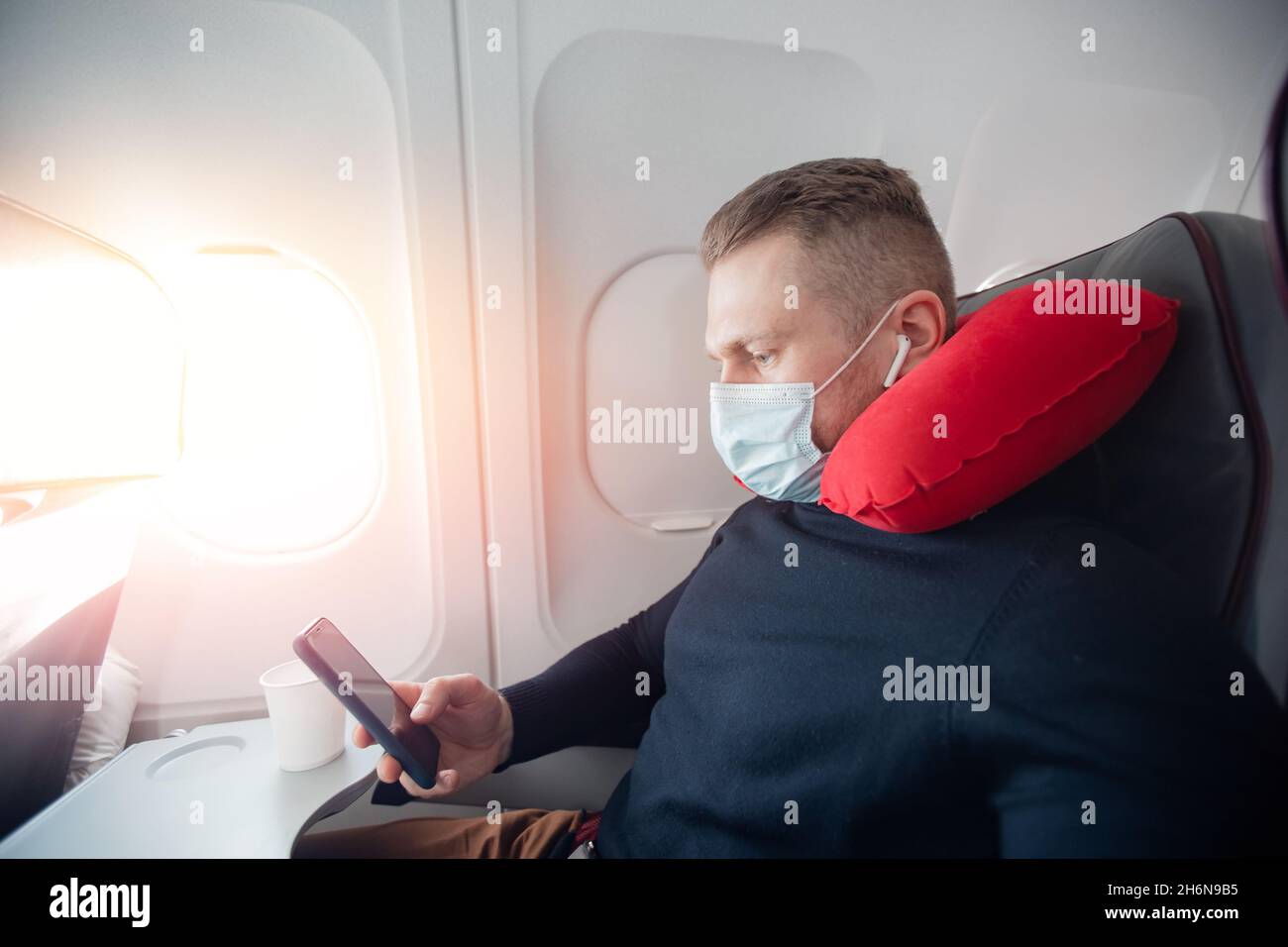 Male with safe mask passenger of airplane use phone in chair. Concept ...