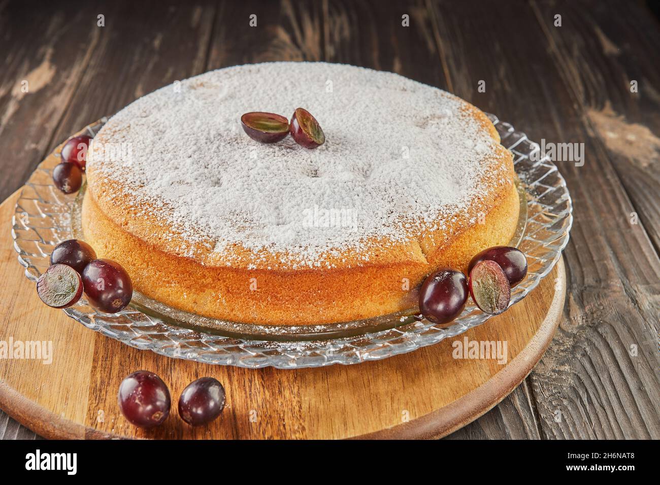 Grape pie with powdered sugar and grapes on wooden background. French ...
