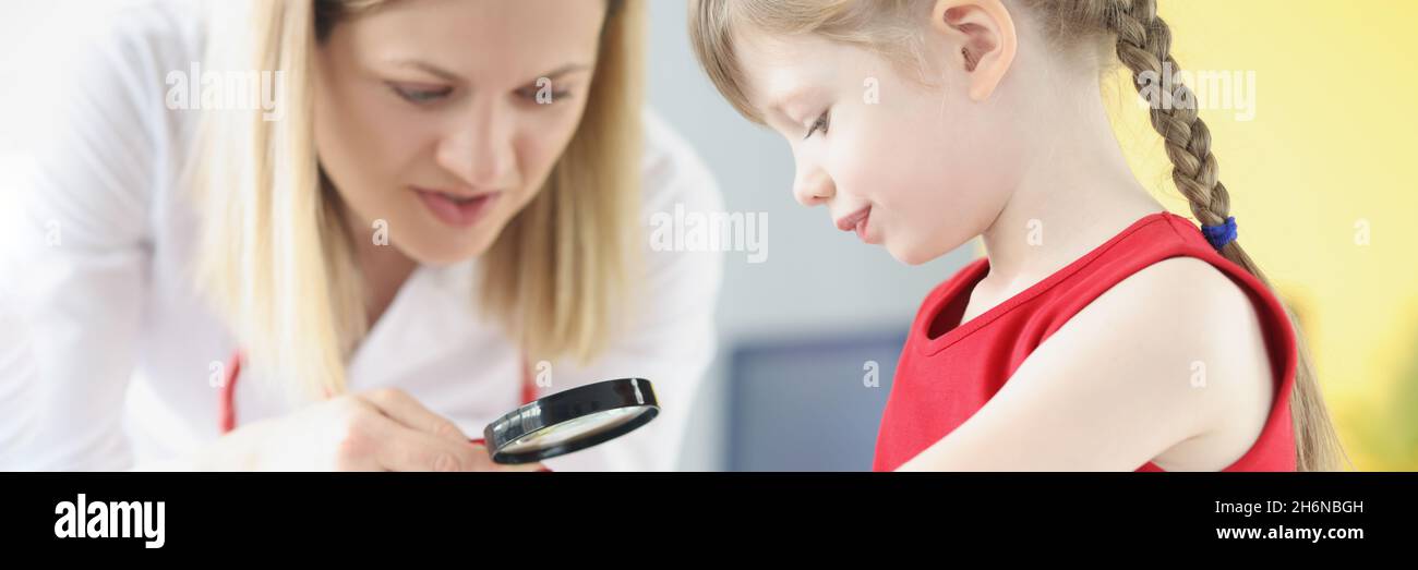Doctor pediatrician examining rash on skin of hand of little girl using ...