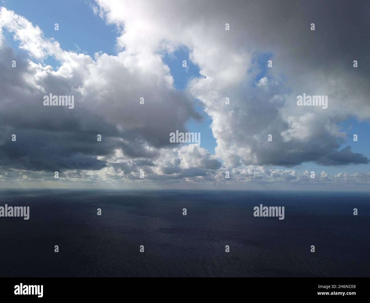 Abstract airy sky with moving plump clouds over the sea ocean. Small ...