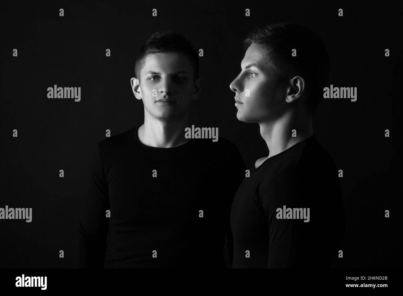 Two attractive positive young twin brothers standing dressed in Stock ...