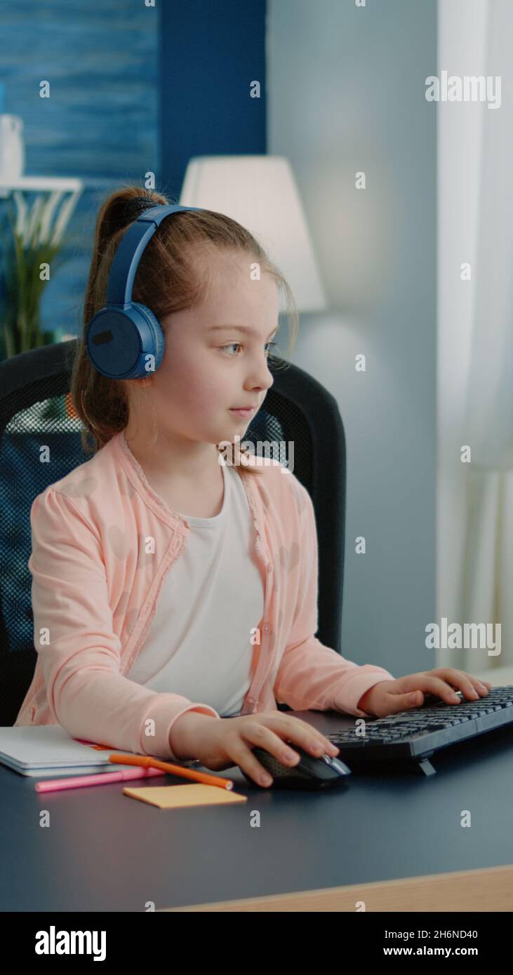 Young child drawing on textbook and using computer while wearing ...