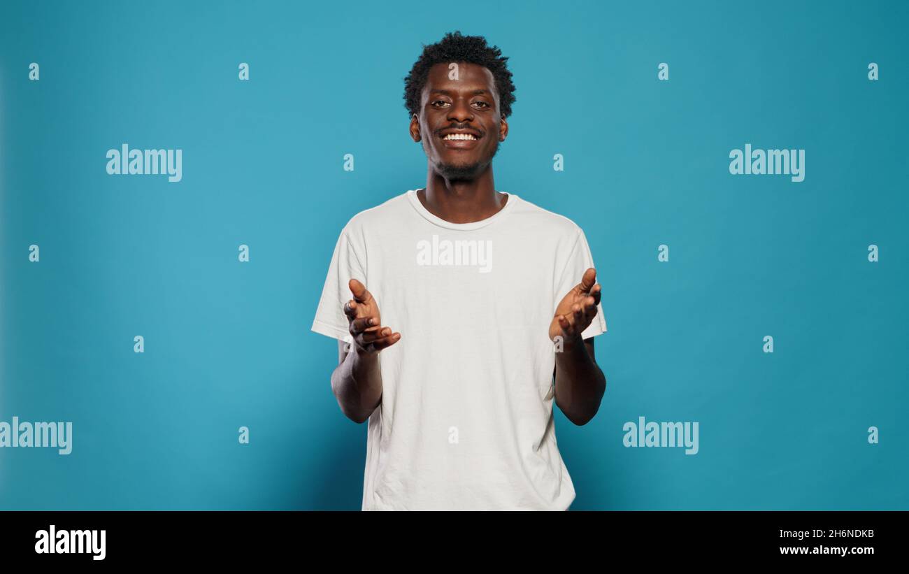 Young adult talking and doing hand gestures on camera in studio ...