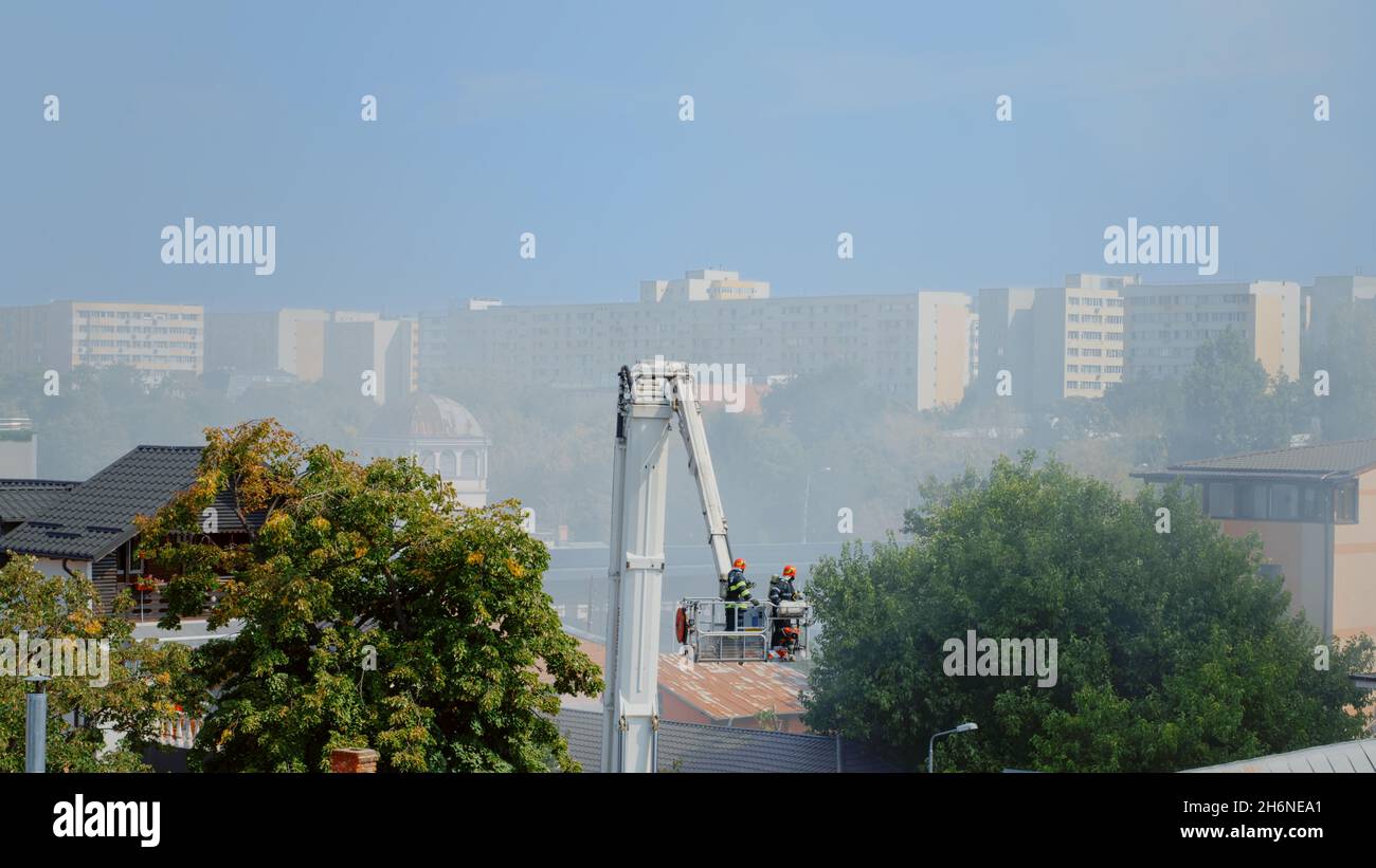View of firefighters using platform truck to extinguish fire from ...