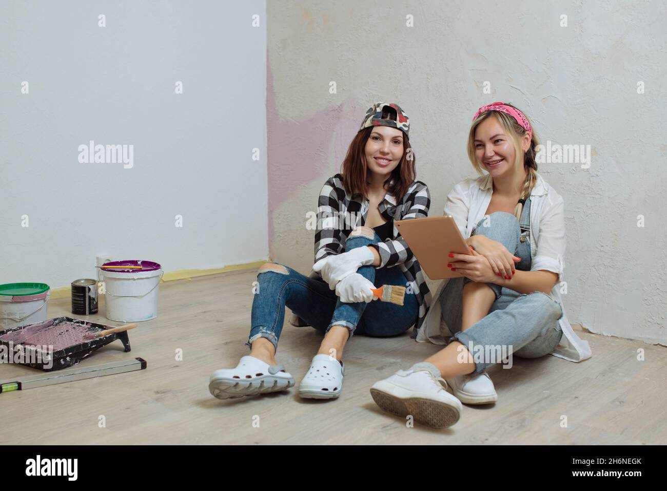 Home interior. Two cute girls designer and painter make repairs in the ...