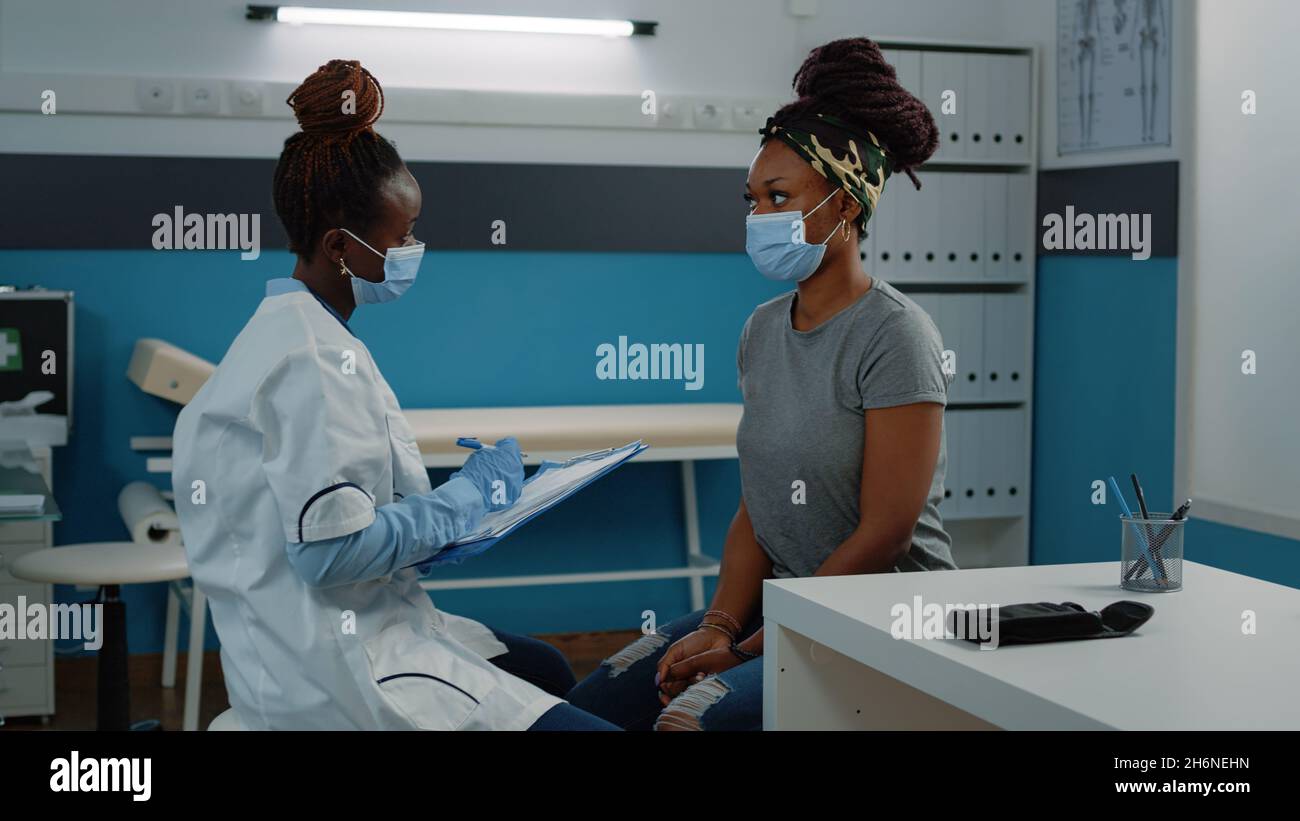 Medic doing healthcare consultation with patient using checkup papers ...
