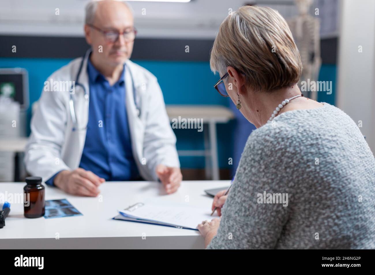 Senior woman with disease signing medical appointment papers with ...