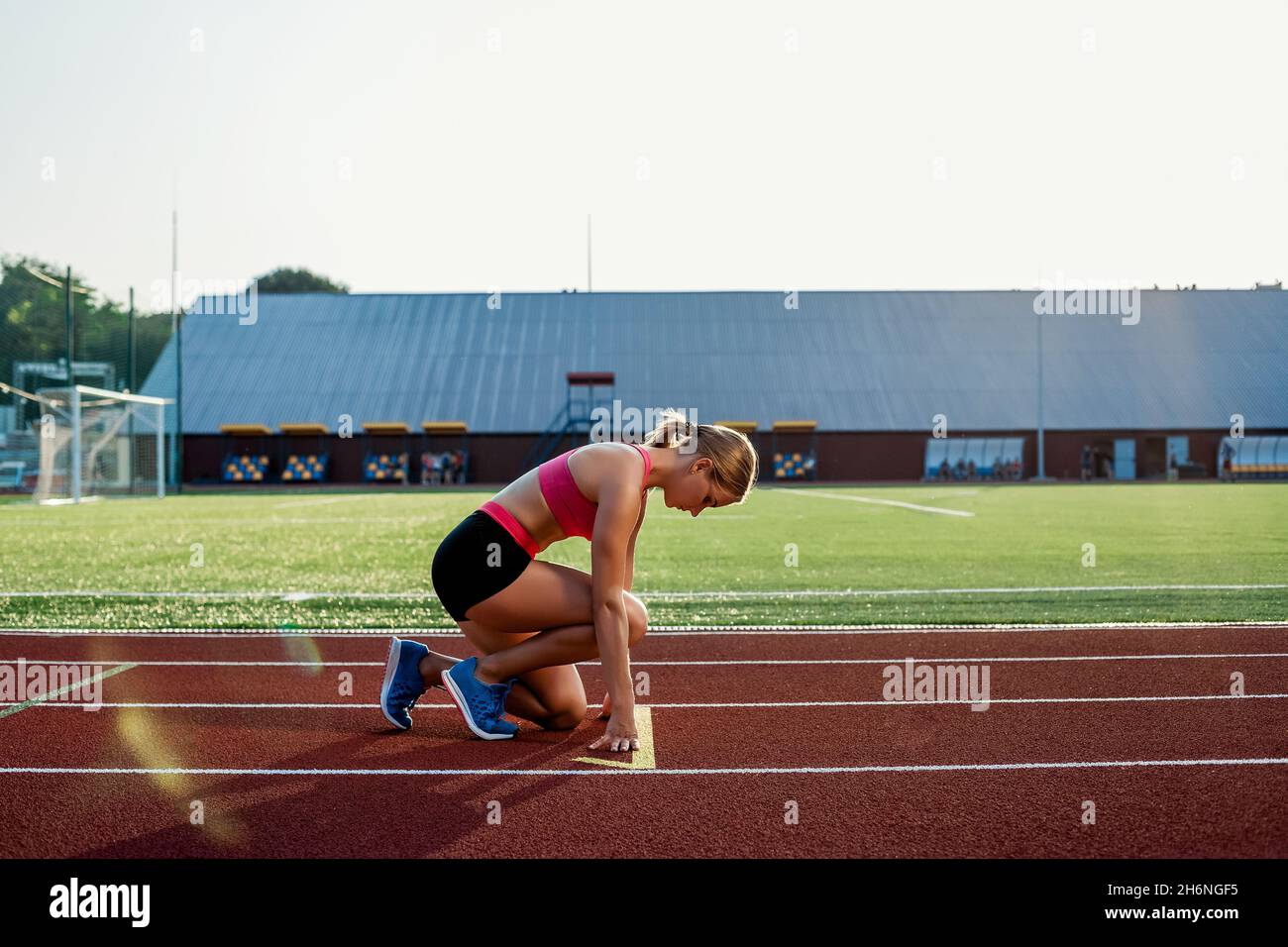 Young woman athlete at starting position ready to start a race on ...