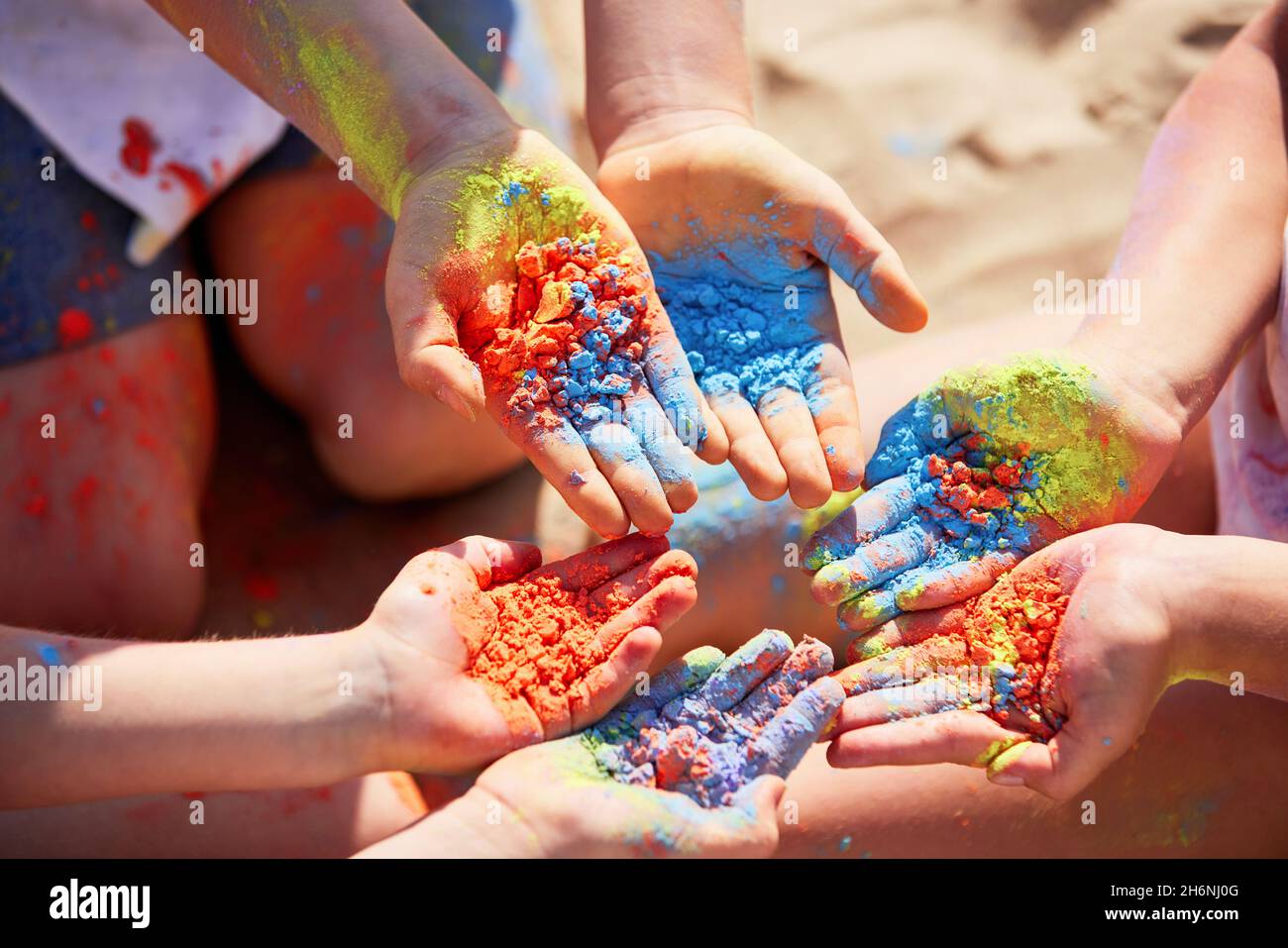 three children holding colorful powder in hands Stock Photo - Alamy