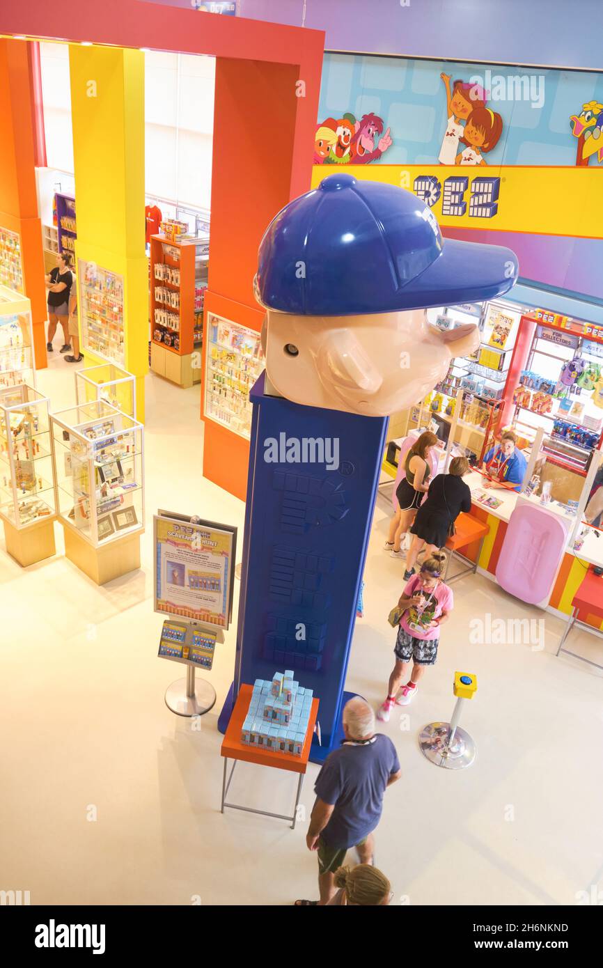 A huge model of a Pez dispenser, man wearing a blue baseball cap. At ...