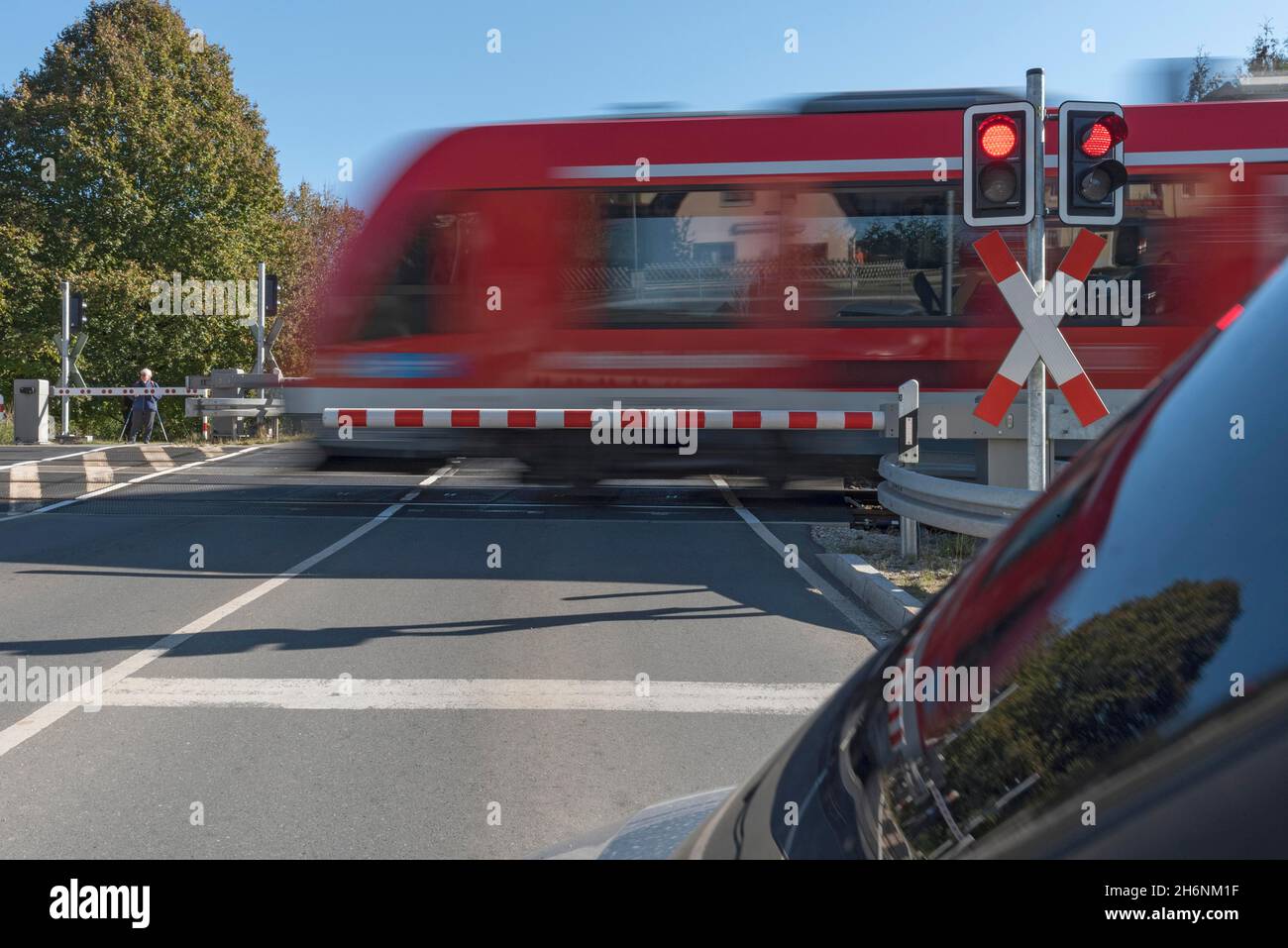 Passing train at a level crossing with barriers, Bavaria, Germany Stock ...