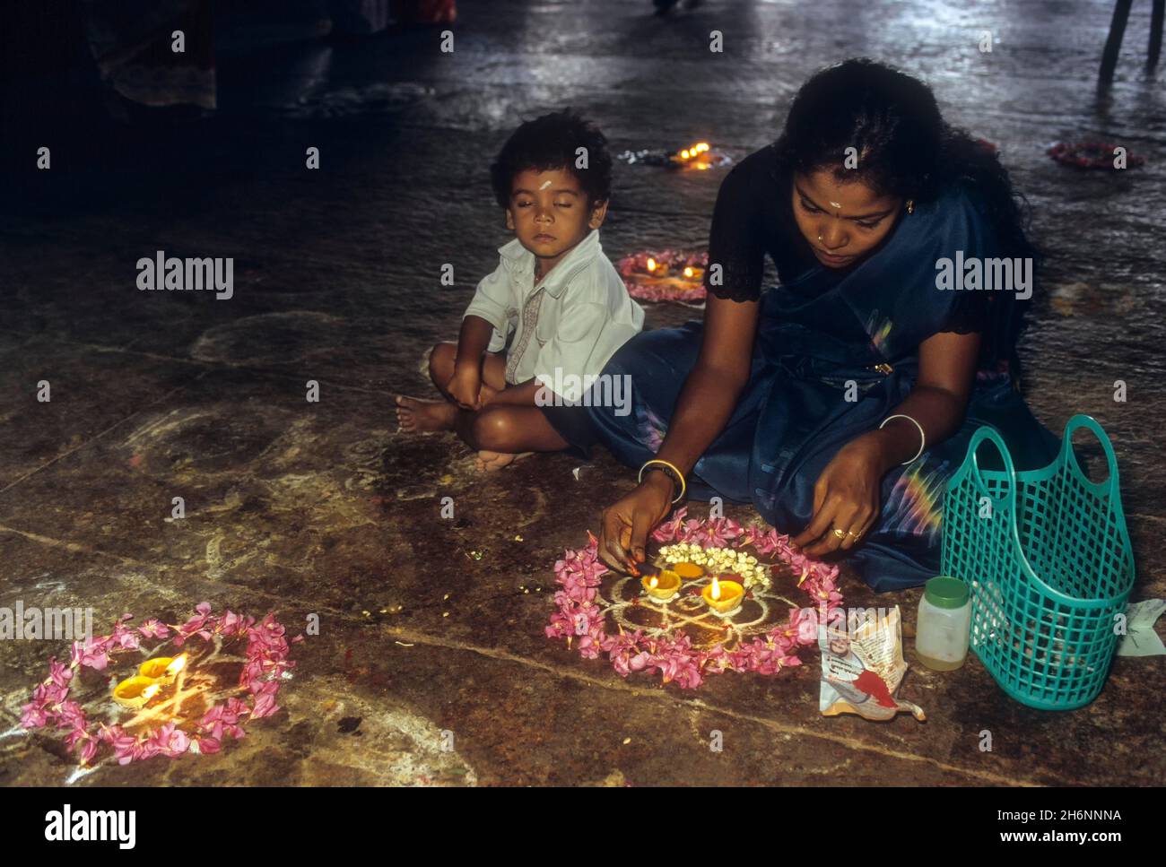 A woman lighting the oil lamp at a temple in Tamil Nadu, India Stock ...