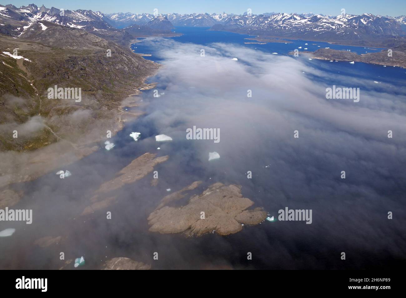 Clouds, icebergs, barren islands and snow-capped mountains, aerial view ...