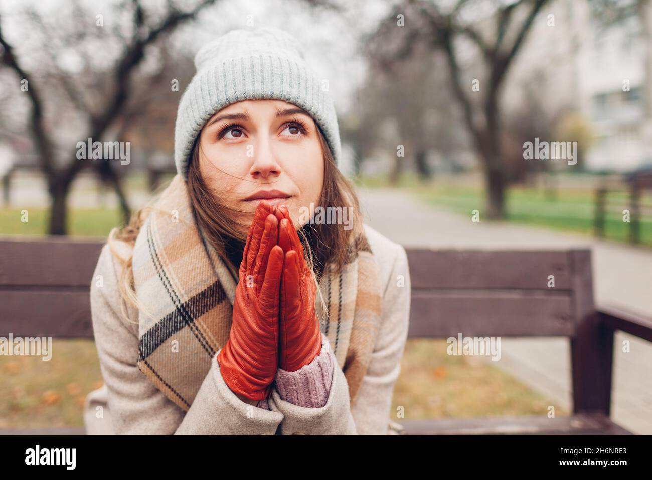 Upset devastated young woman sitting on bench in autumn park crying and ...