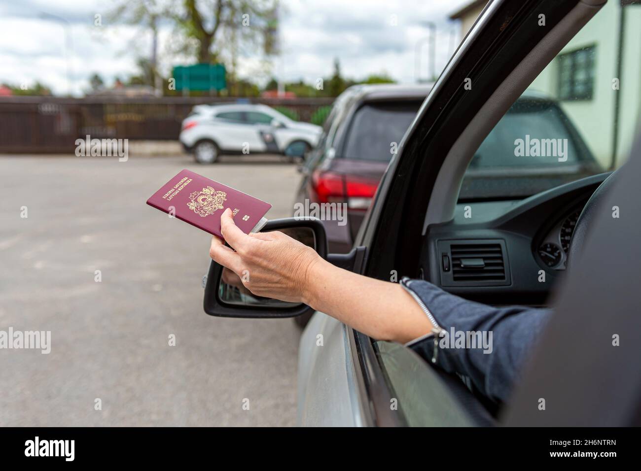 women hand through car window giving passport for customs control ...