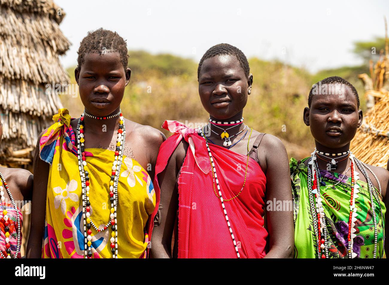 Traditional dressed girls from the Toposa tribe sitting in a grain ...