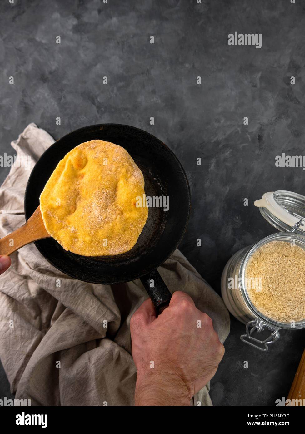 Homemade corn flatbread meal frying pan in male hand. Handmade mexican ...