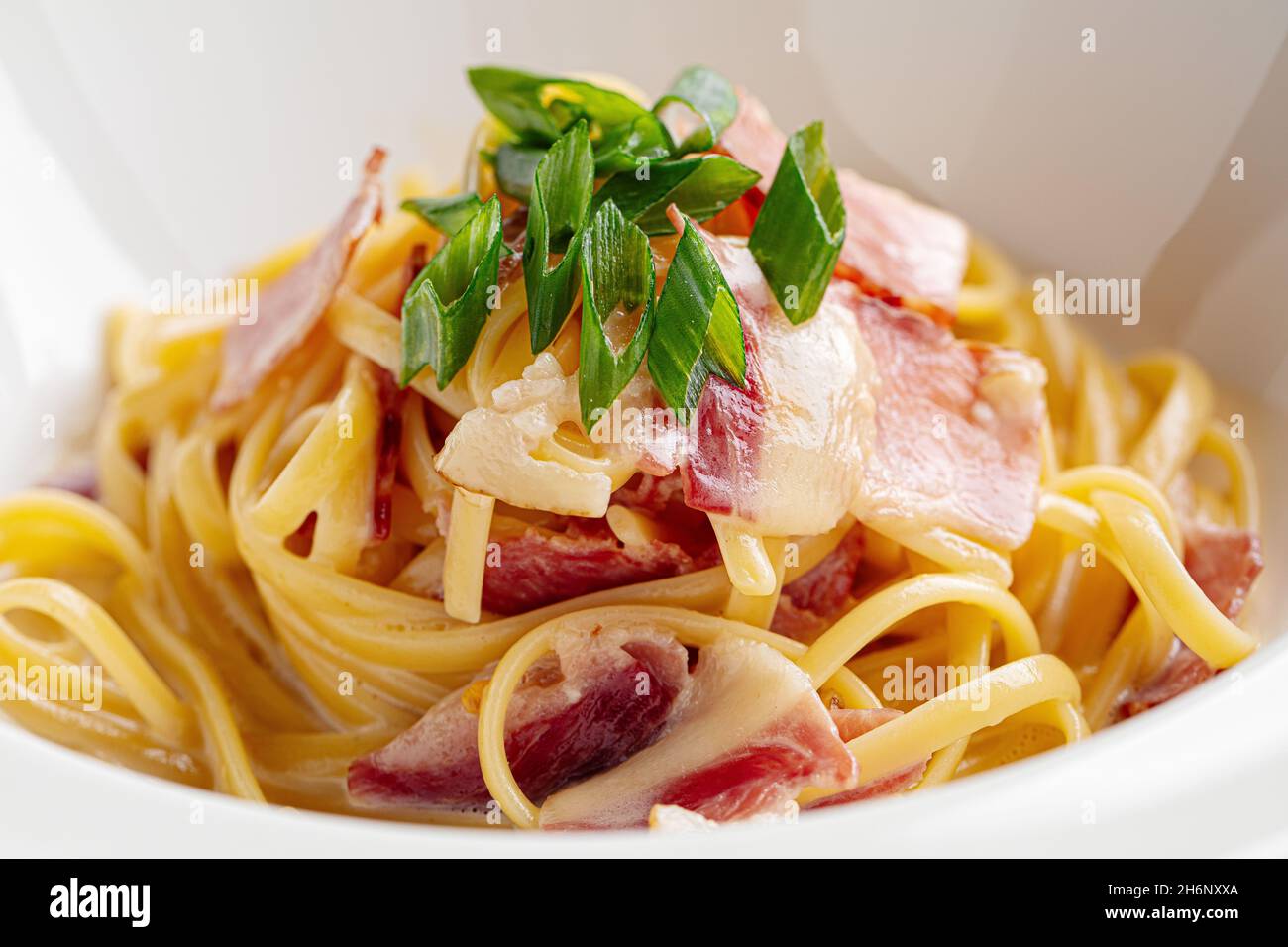 Cooked italian carbonara spaghetti pasta garnish Stock Photo - Alamy