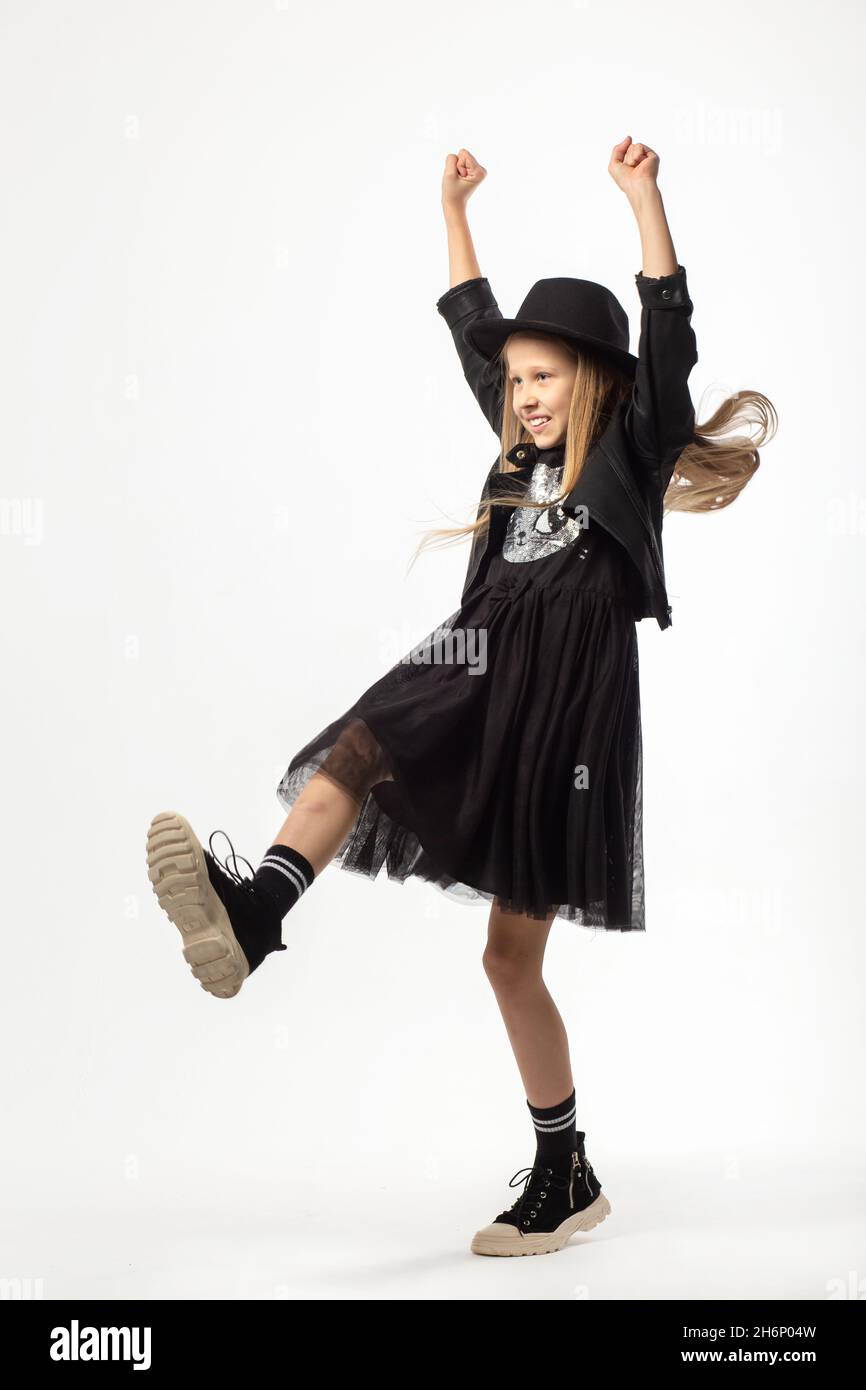 A full-length portrait of dancing young girl with long brown hair ...