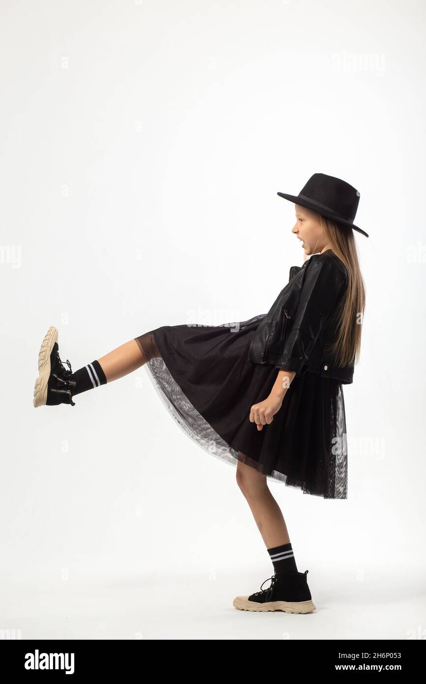 A full-length portrait of dancing young girl with long brown hair ...