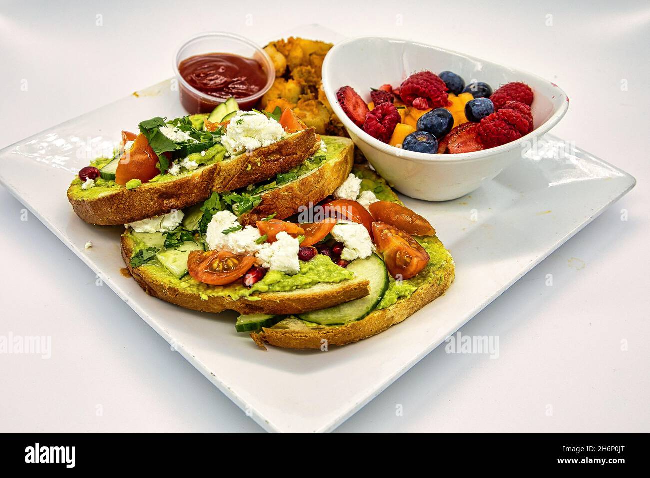 Avocado toast California style with fresh fruit Stock Photo - Alamy