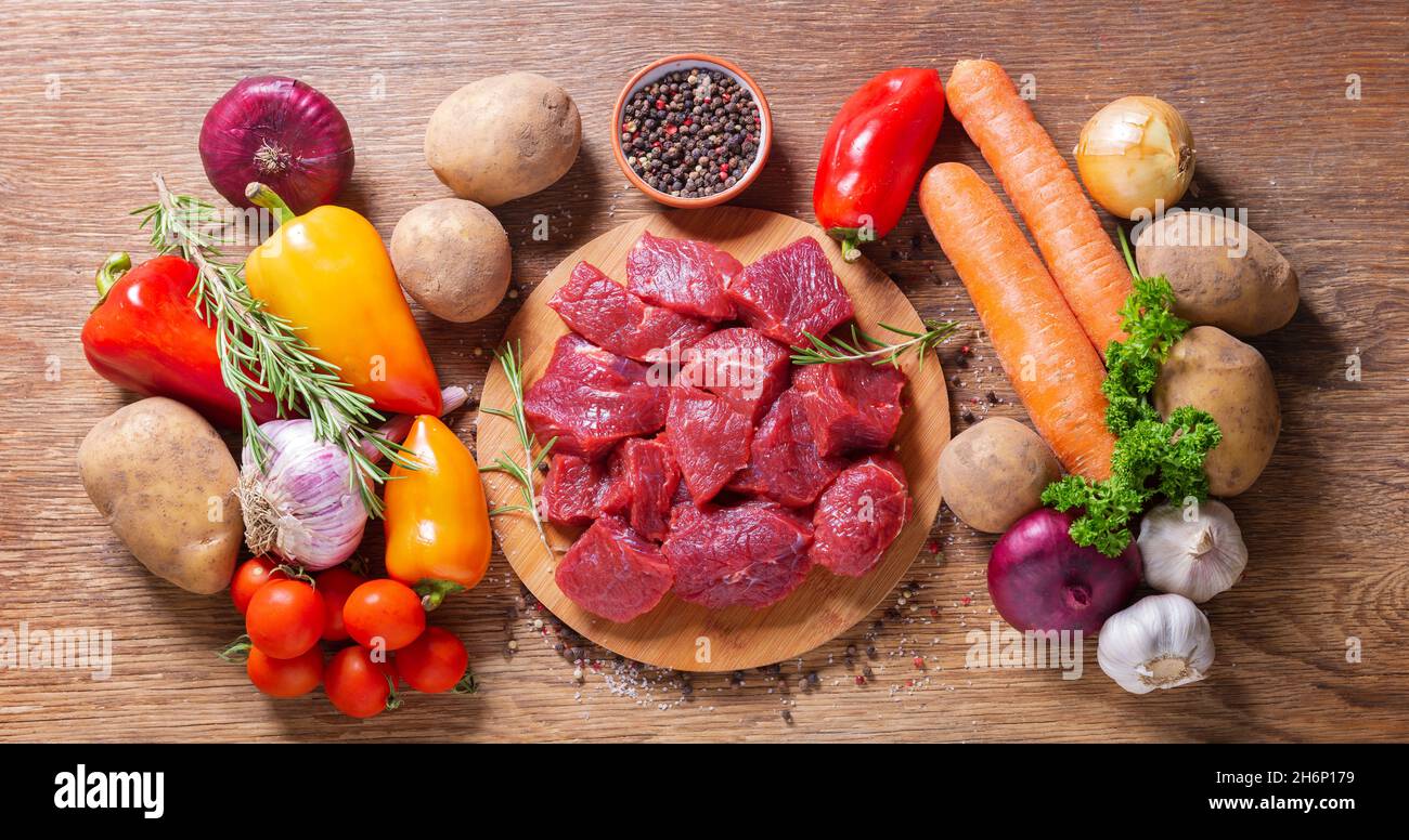 fresh chopped meat with rosemary and ingredients for cooking on wooden ...
