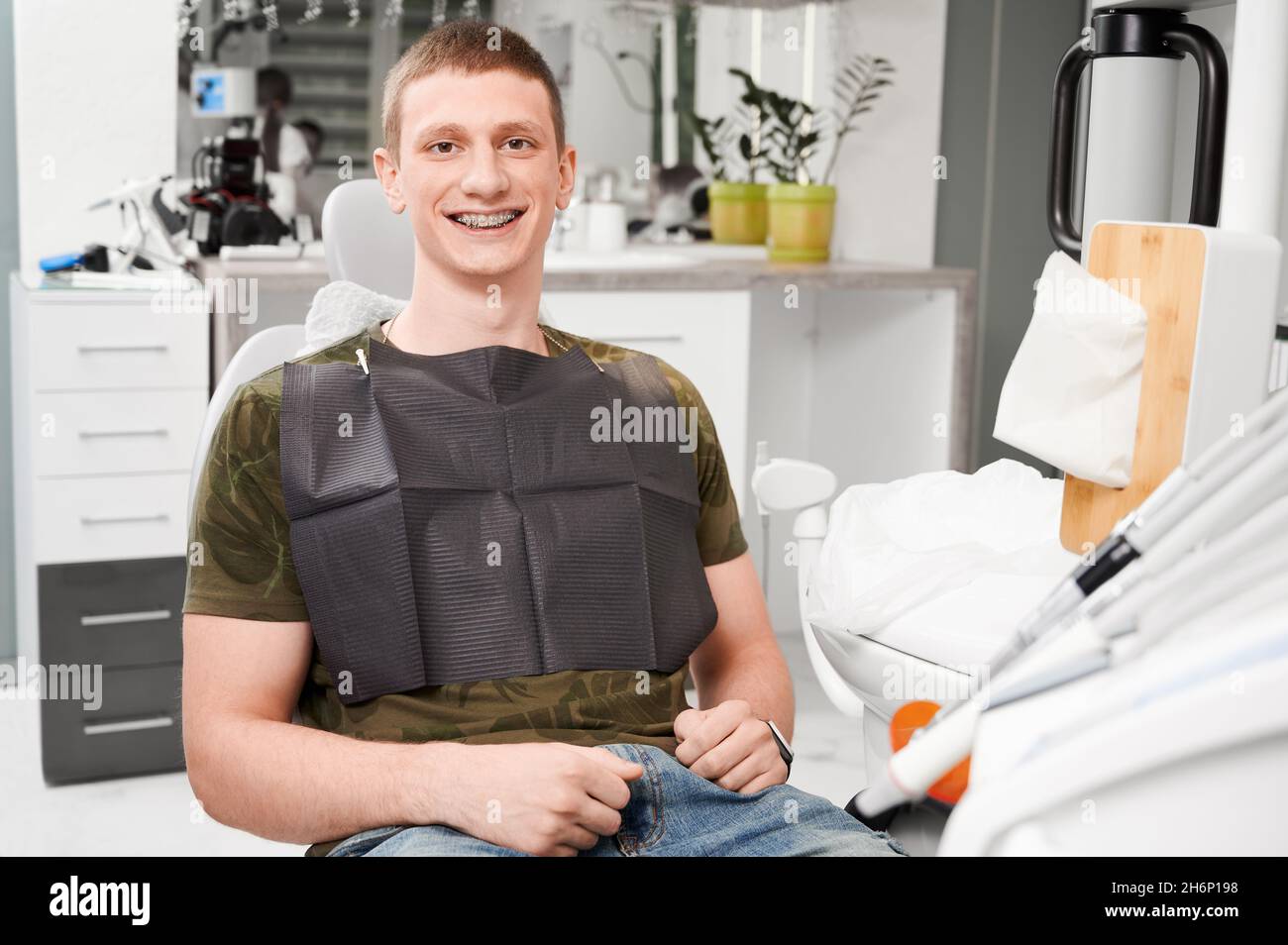 Young man with dental braces on his teeth visiting dentist office ...