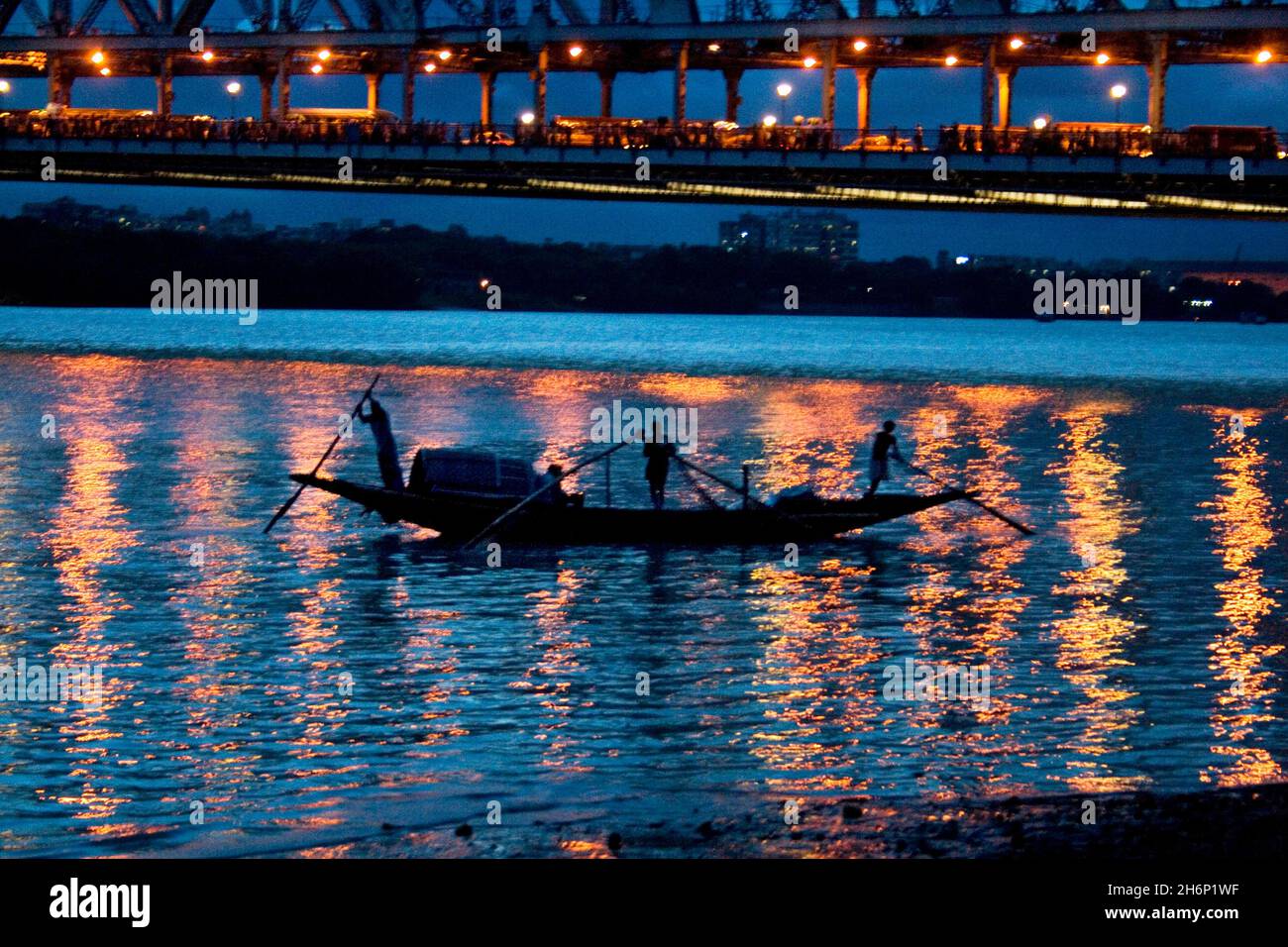 A fishing boat under the Howrah bridge, a famous symbol of Kolkata and ...