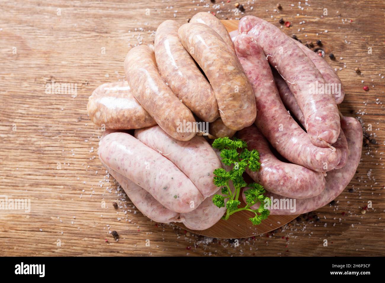 various kind of types of fresh sausages with spices on chopping board ...