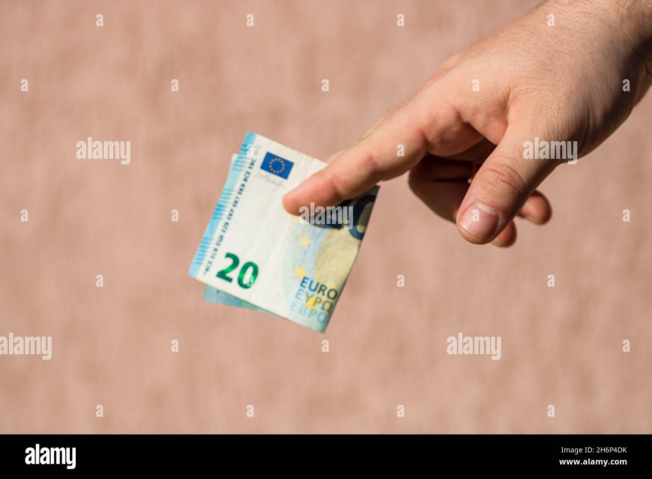 Closeup of a male hand holding euros on a brown background Stock Photo ...