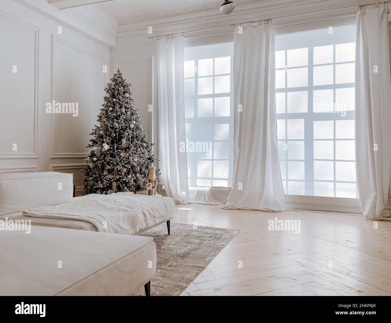 Christmas tree with gifts in white living room Stock Photo - Alamy