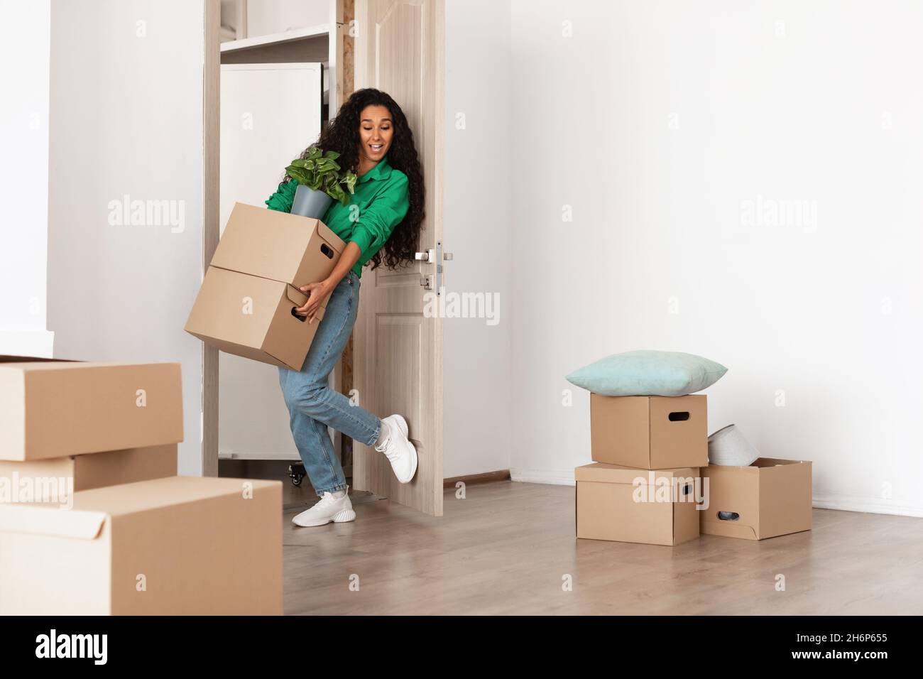 Lady holding cardboard boxes, walking in new house Stock Photo - Alamy