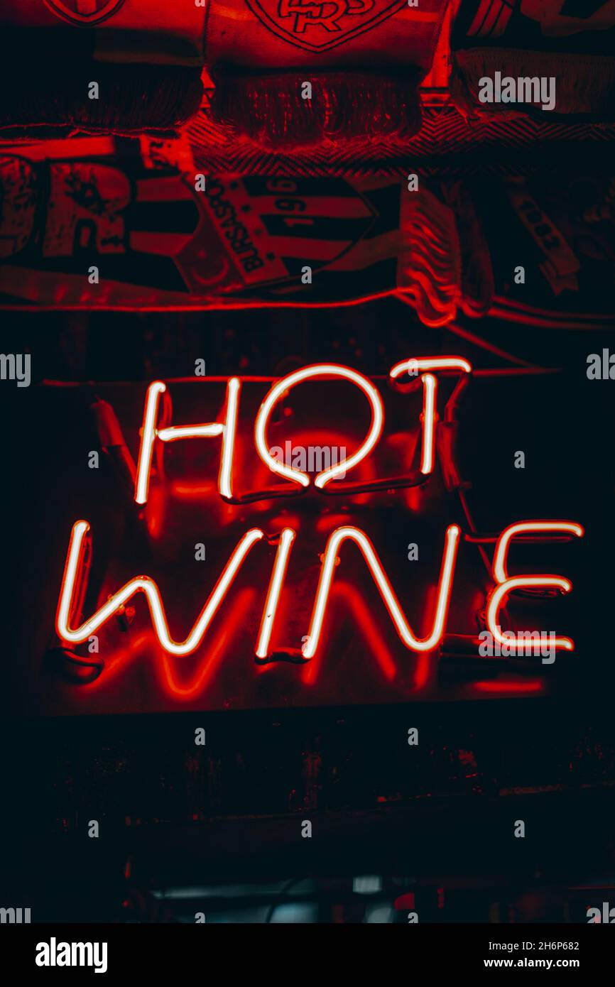 Neon sign phrase ' Hot Wine '. Bright glowing red neon sign in cafe ...