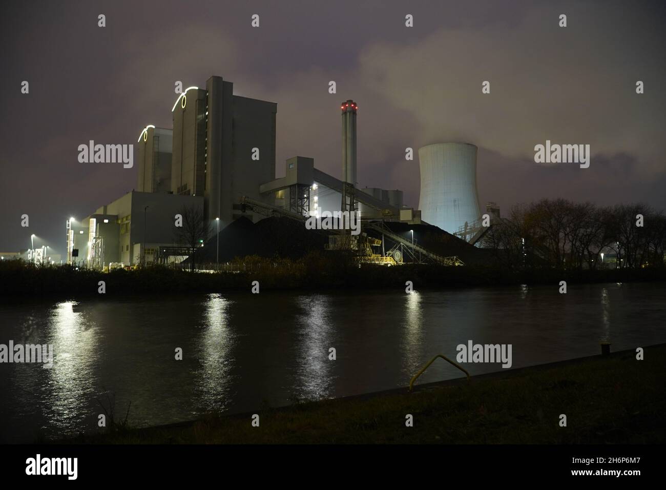 Coal-fired power plant with stone coal stockpile by night. Old ...