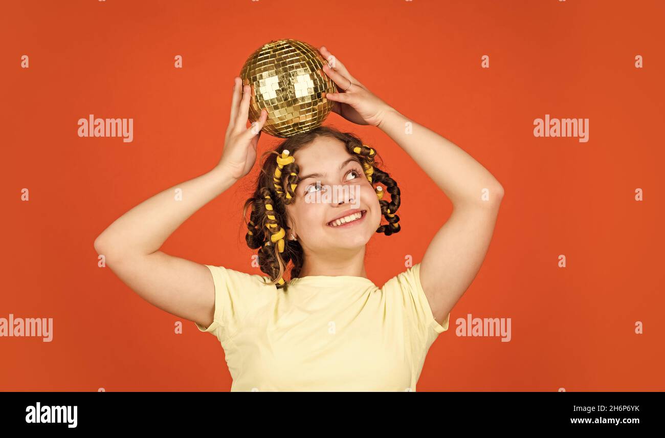 Retro party. Child hold golden disco ball. Cheerful girl with disco ...