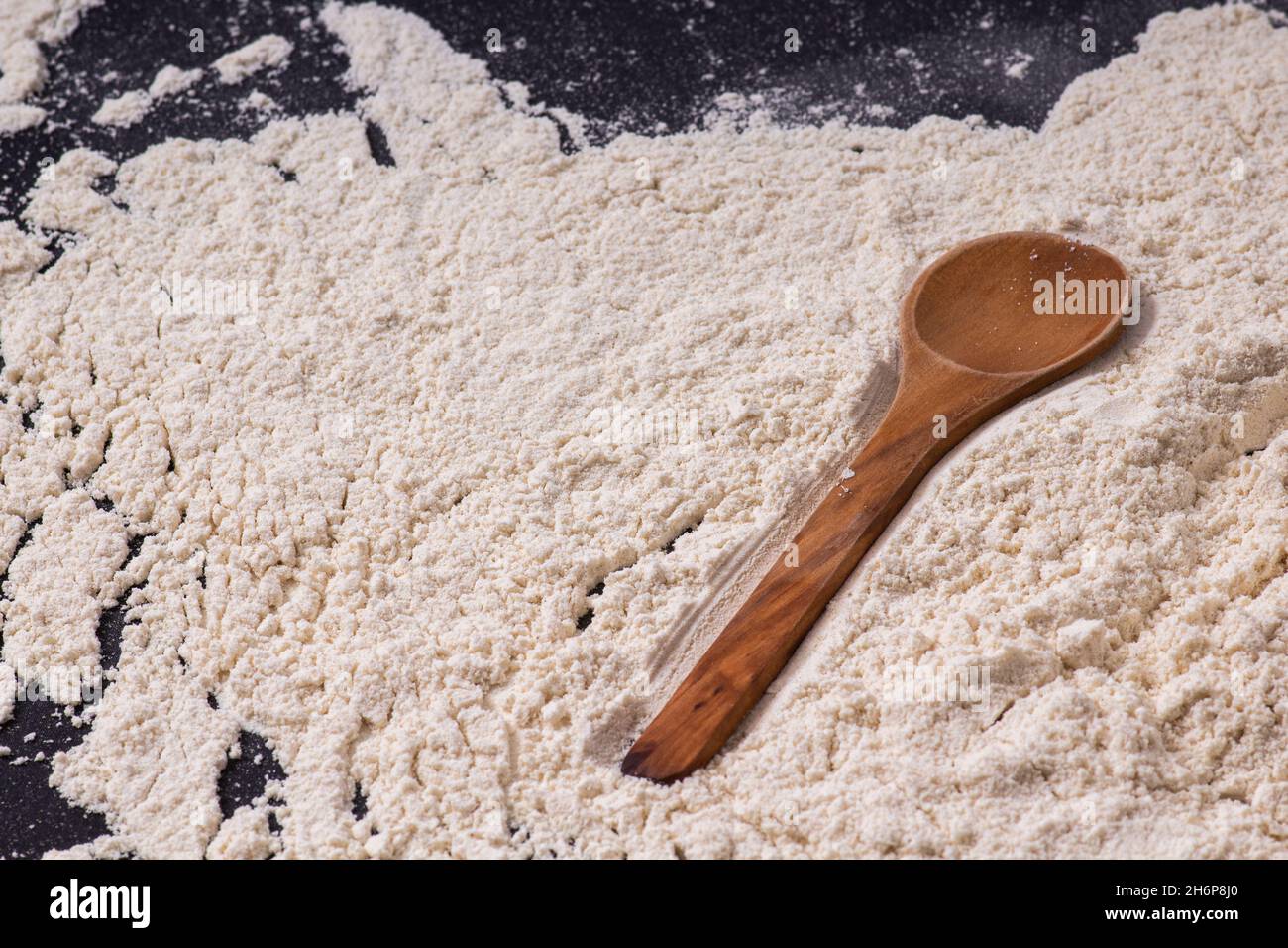 Closeup of the wooden spoon on the table covered with flour Stock Photo ...