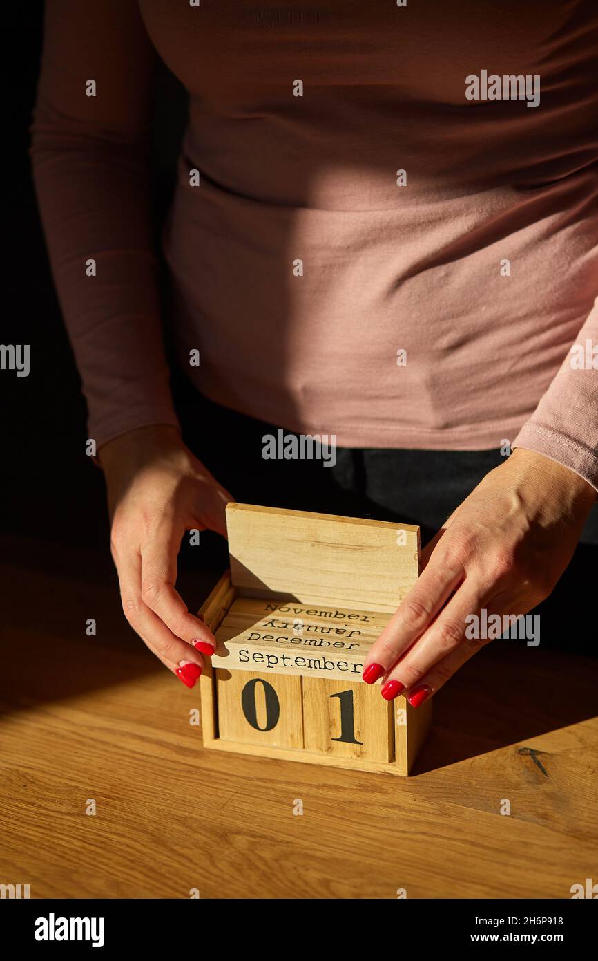 Woman hand change, sets the date on the wooden calendar on 01 January ...