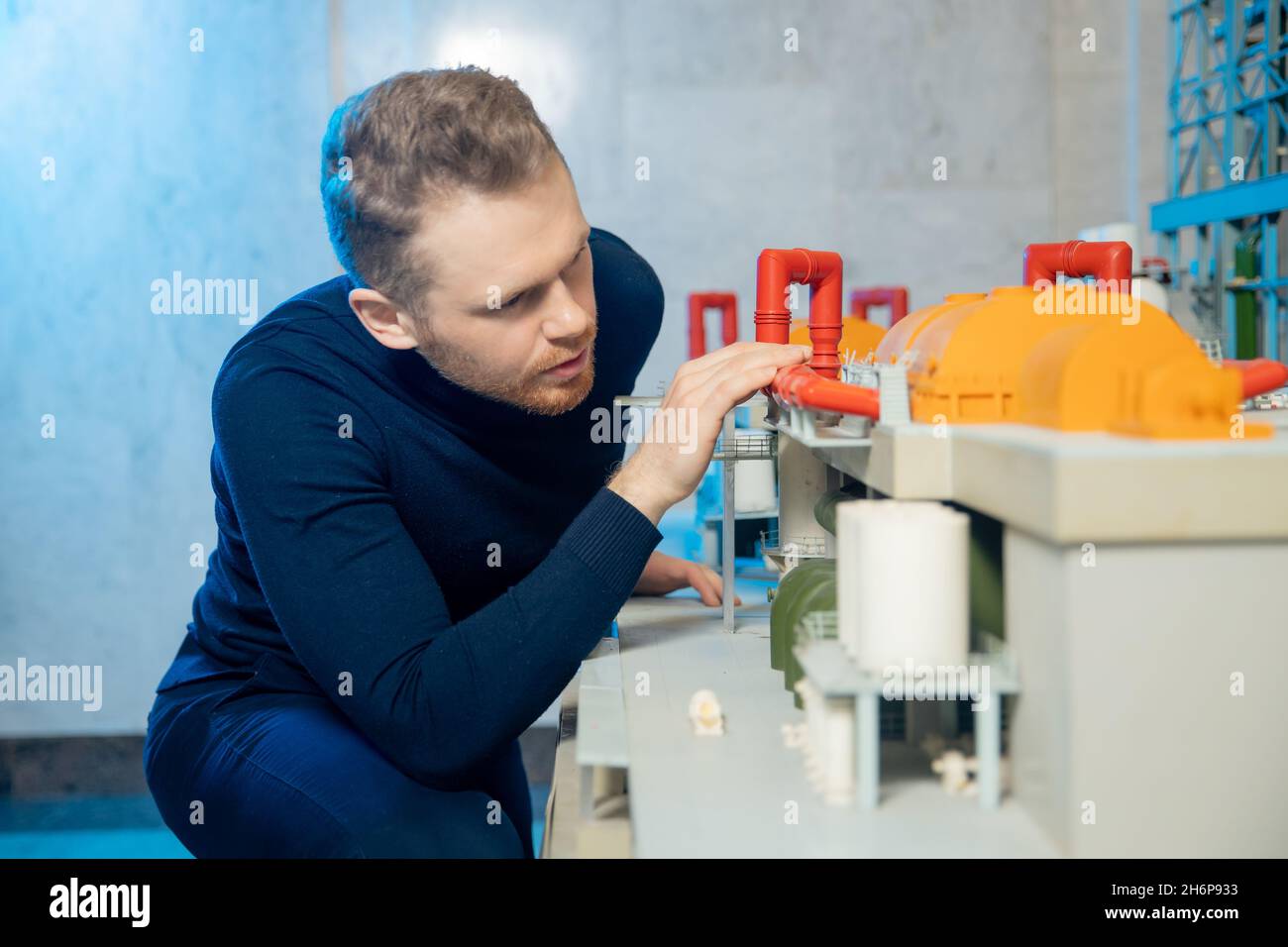 Young construction engineer man is studying layout of structure of ...