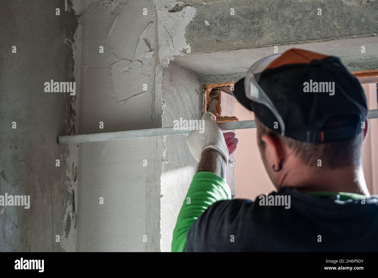 A plastered wall is being leveled with an aluminum rule. The concept of ...
