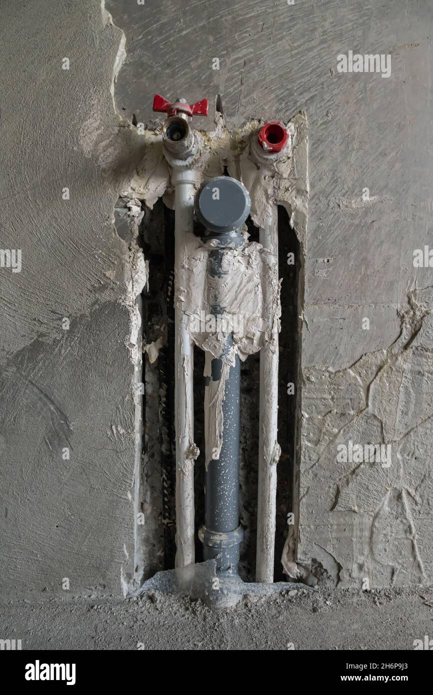 There are three plastic pipes in the concrete wall. Two for cold and ...
