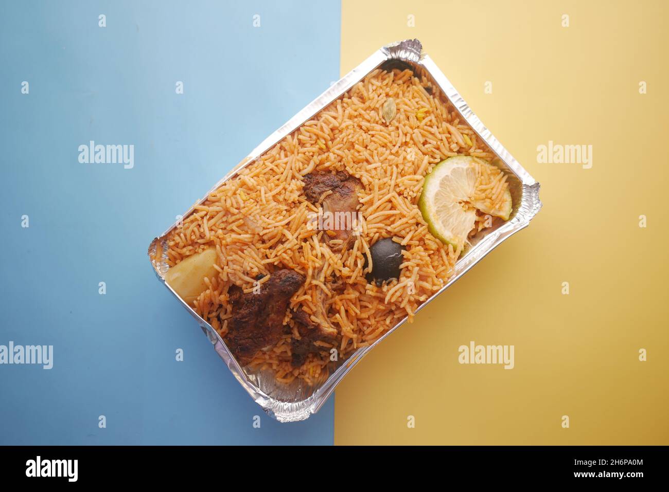mutton biryani meal in a plastic take away box on color background ...