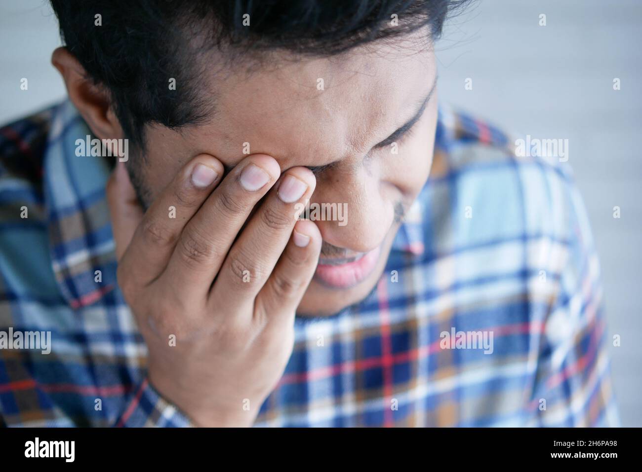 Close up of upset man suffering from strong eye pain Stock Photo - Alamy