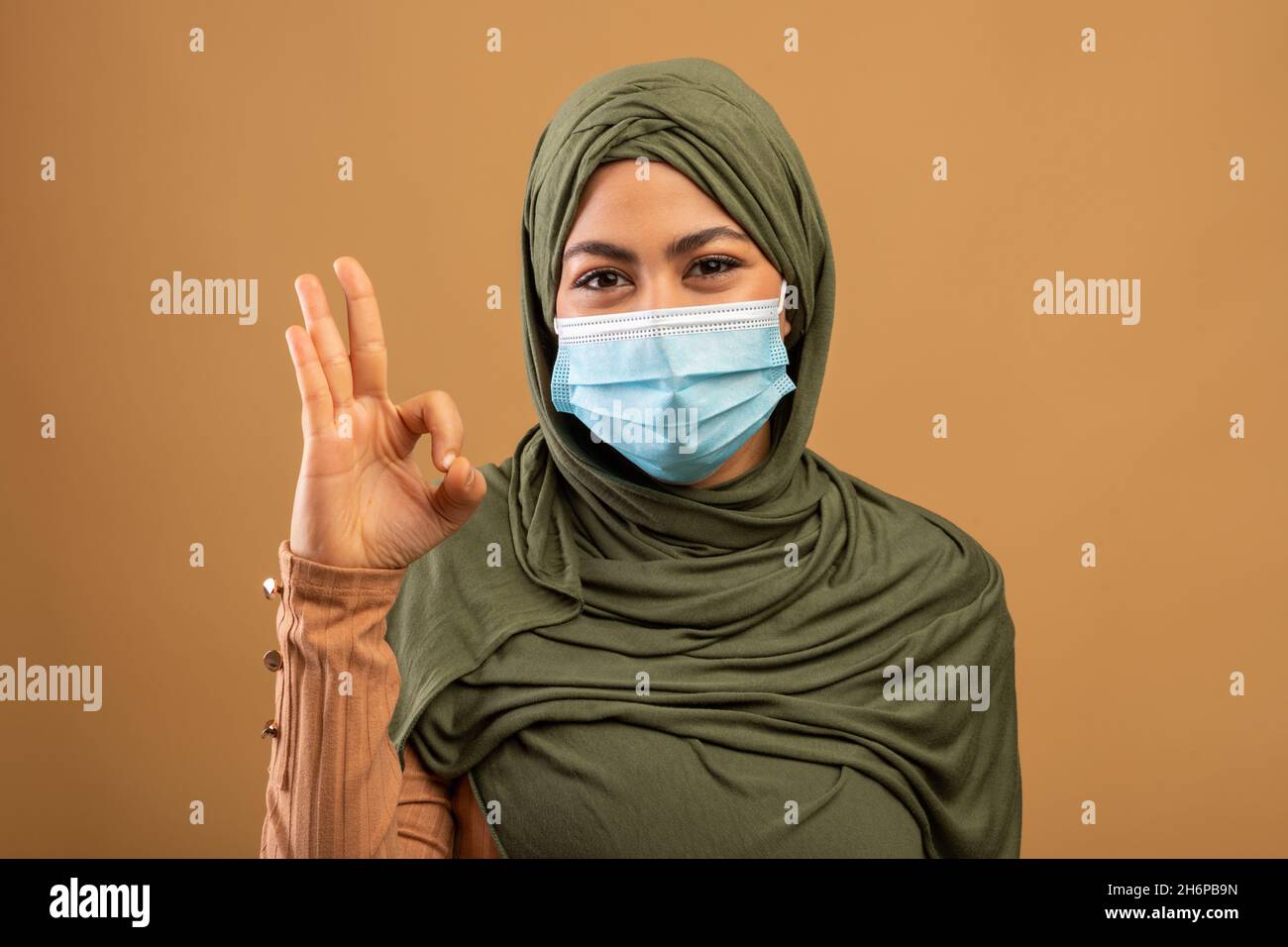 Protection against disease. Muslim woman in hijab wearing medical ...